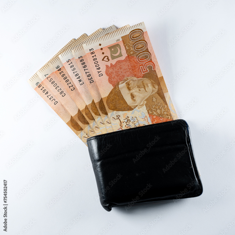 Five thousand 5000 rupee bank notes aligned with a black leather wallet ...