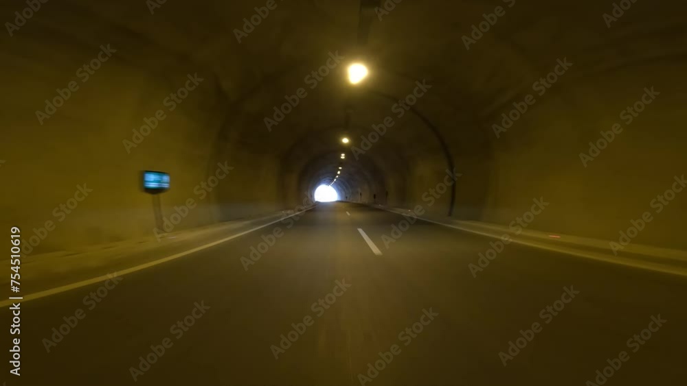 Car exits tunnel, revealing highway. Footage highlights underground ...
