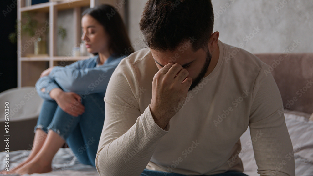 Annoyed Caucasian husband sit apart on bed with offended wife keep ...