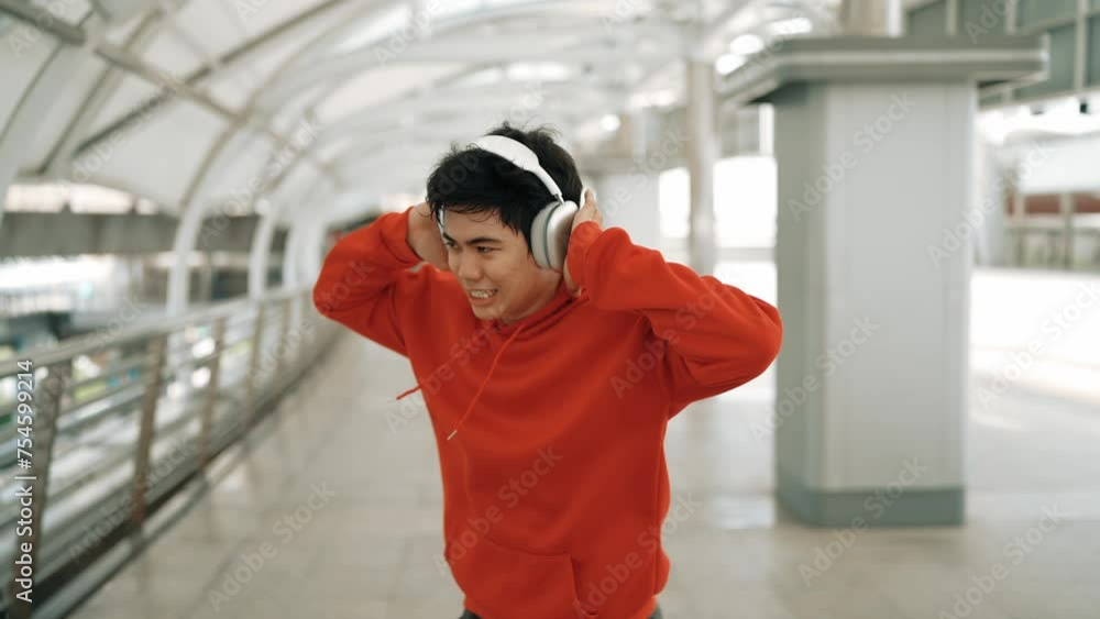 Dancer listen to hip hop music while sing along and walking at corridor ...