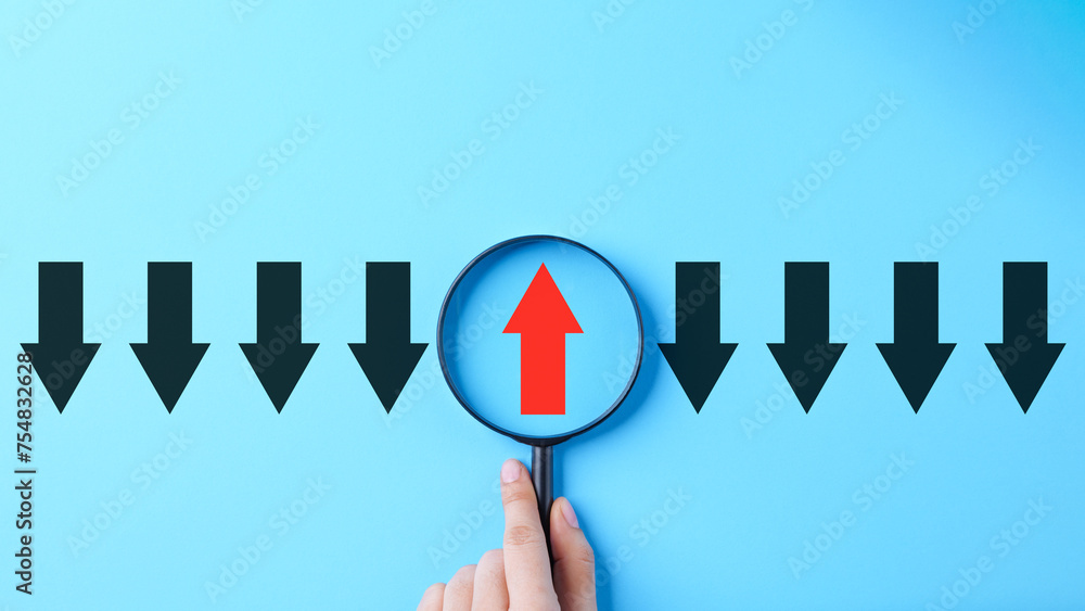 Difference concept. A single red upward arrow is view through ...