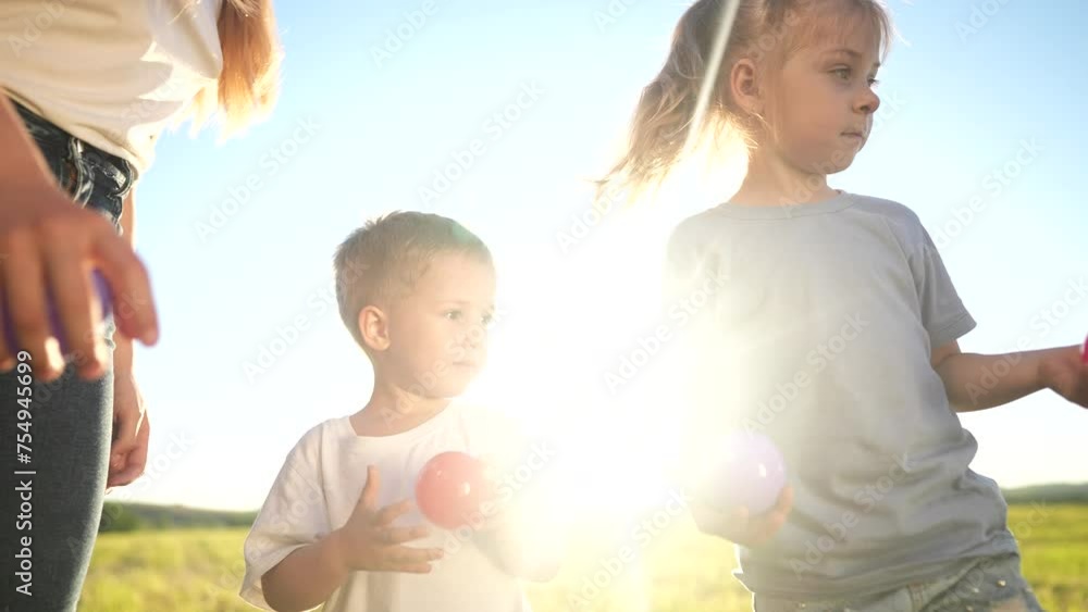 children conduct a relay race in nature in the park. happy family ...