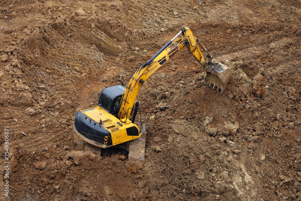Crawler excavator scoops the earth with a bucket, top view. Earthmoving ...