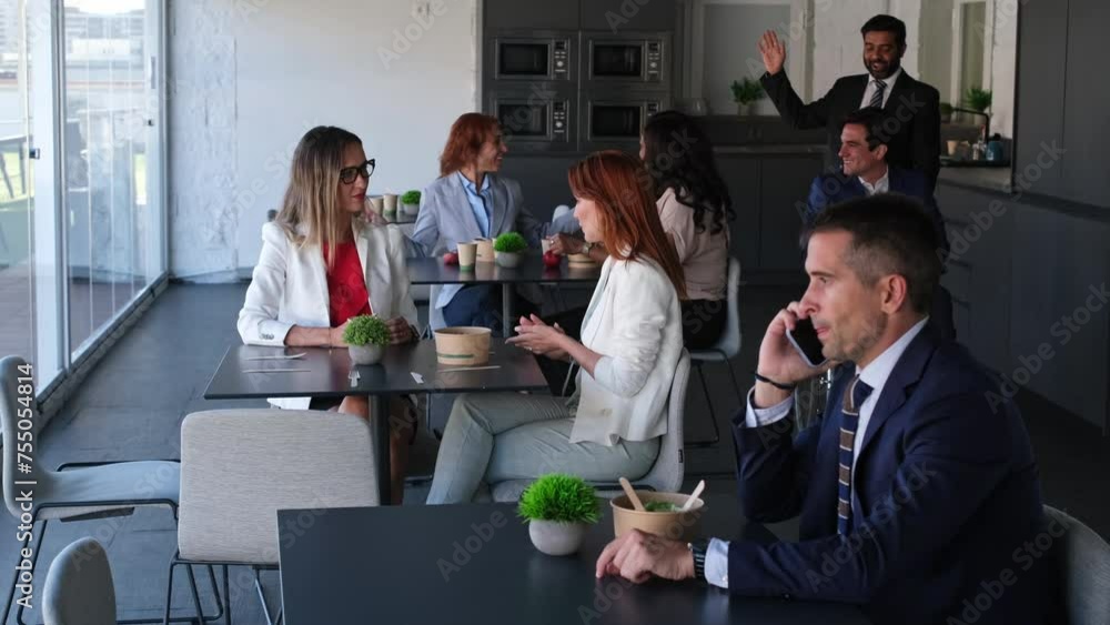 Worker in a wheelchair greeting his coworking colleagues in the lunch ...