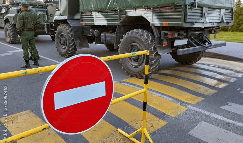 Armed soldiers standing near a roadblock with a no entry sign in the ...