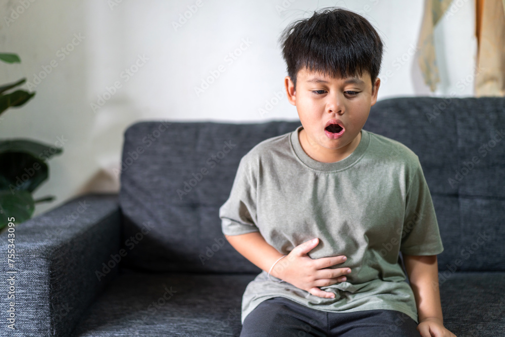 Portrait of sick unhappy little child asian boy touching belly stomach ...