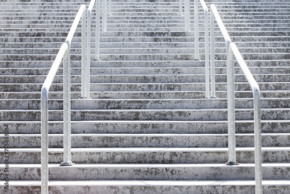 Long massive cementr stairs. Many steps background. Metal handrail ...