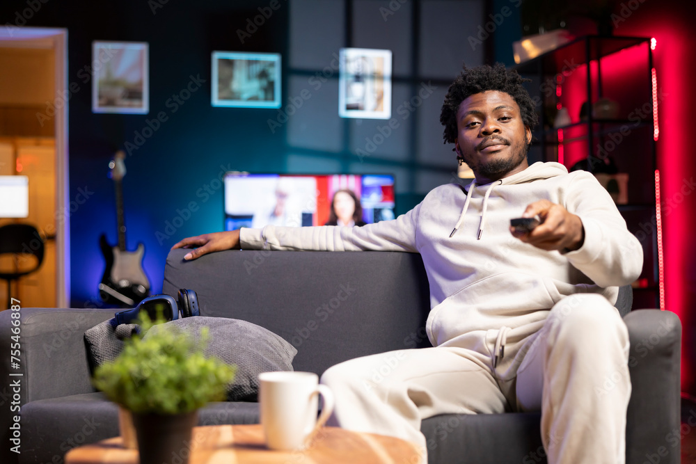 Man zapping through TV channels using remote, enjoying leisure time in ...