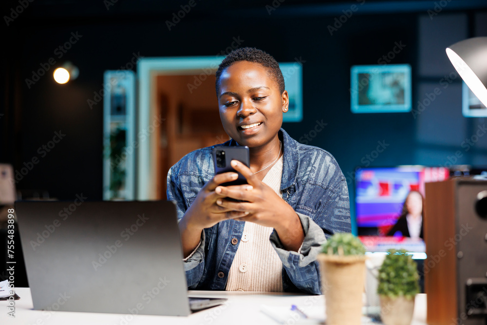 African american lady with positive emotion, using mobile device to ...