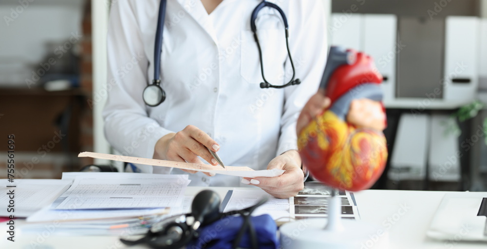 Doctor cardiologist examining cardiogram against background of ...