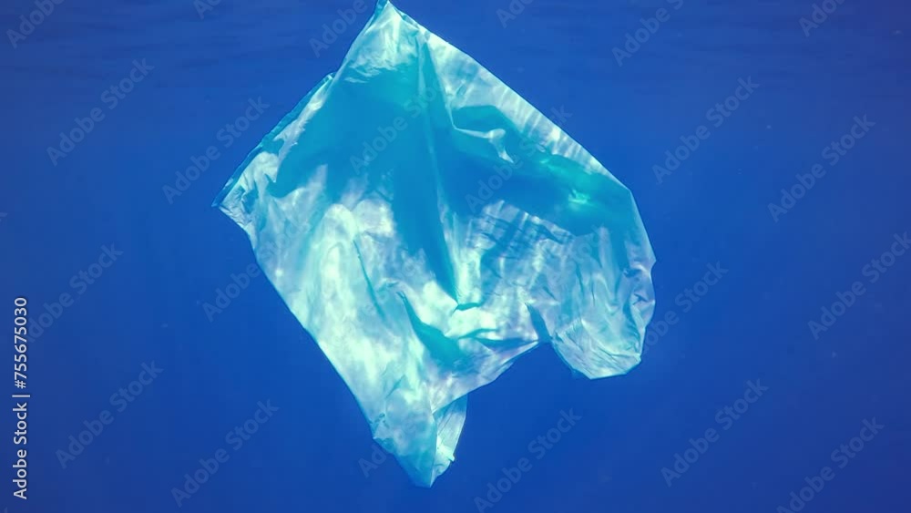 Disposable light blue plastic bag drifts underwater, close-up. Plastic ...