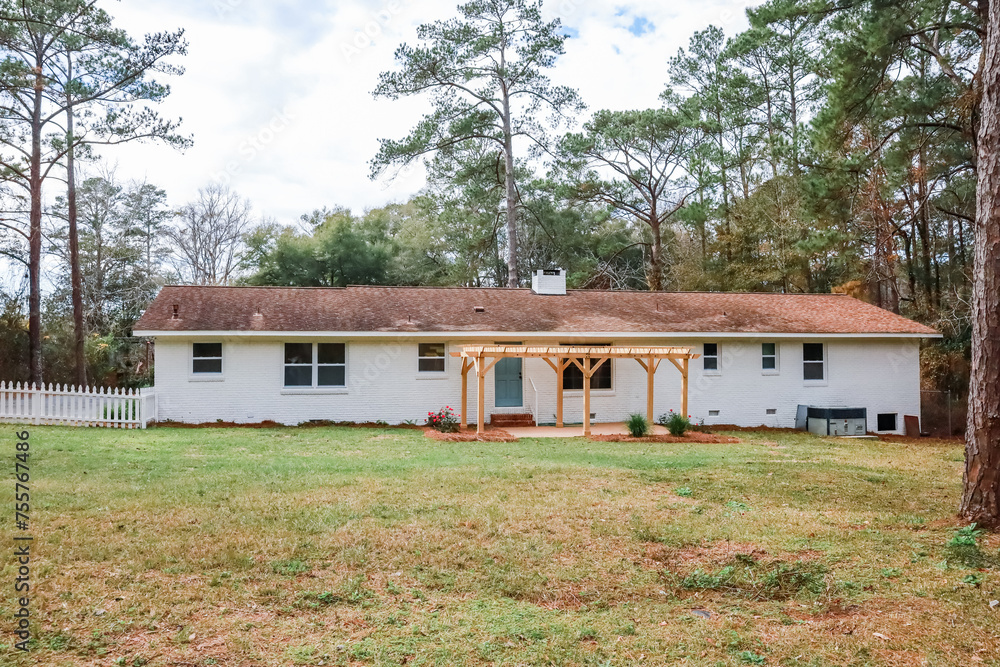 The rear back exterior of a newly painted and renovated white brick ...