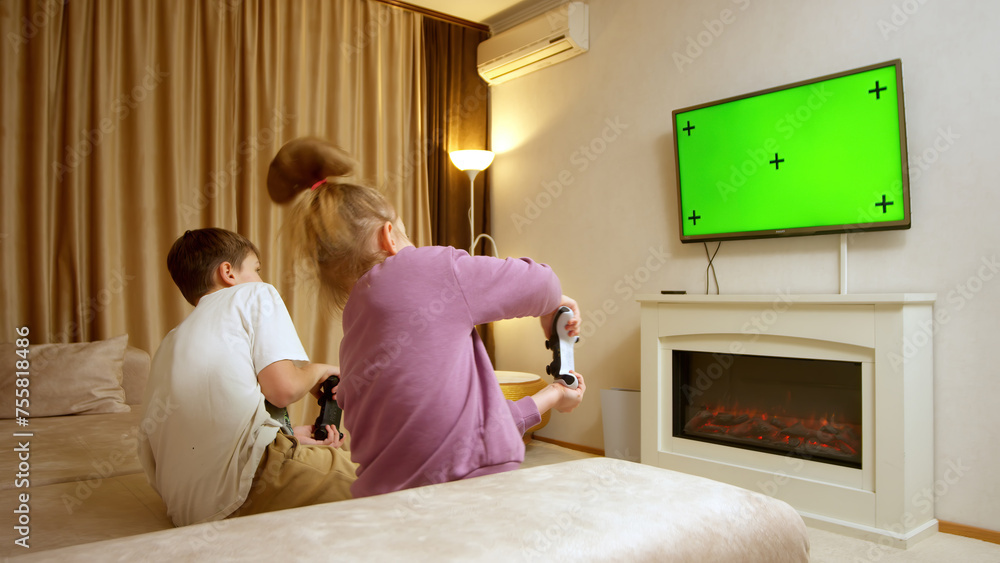 Children in a home interior enjoying playing a game console against a ...