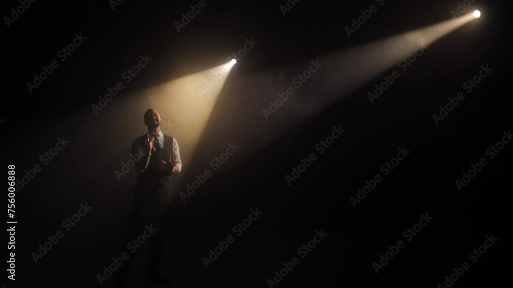 Handsome opera singer dressed in vest performing on stage in crossing ...