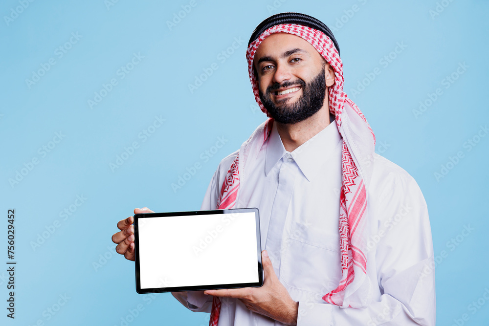 Smiling arab man presenting digital tablet empty screen for app ...