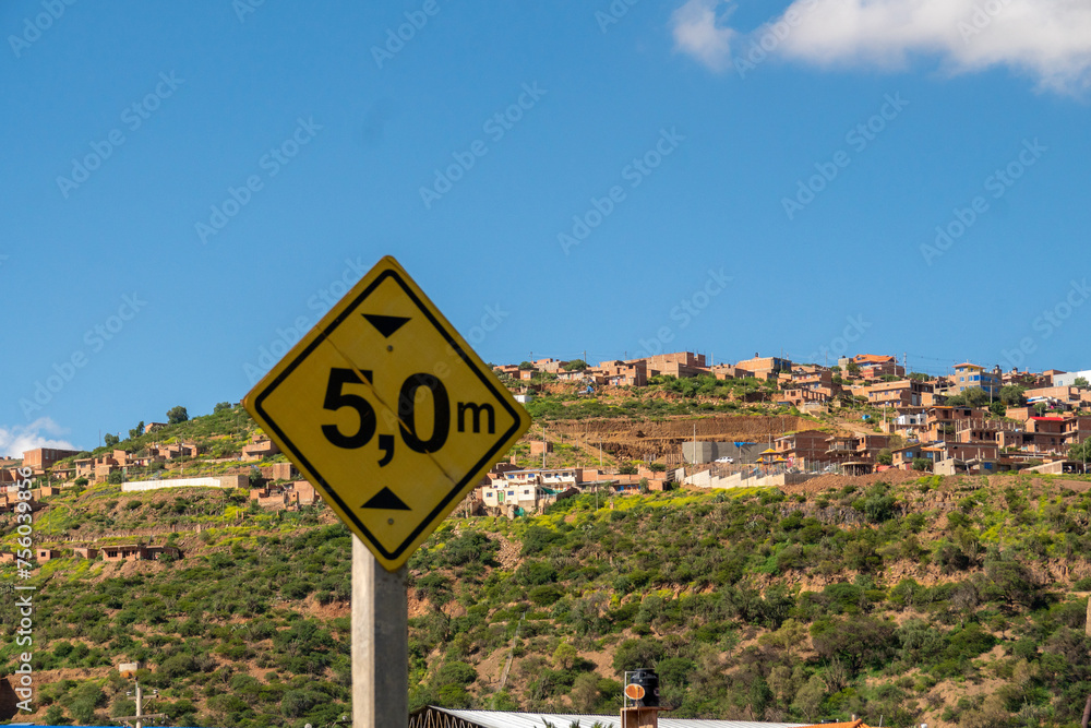 road traffic signs indicating height difference, village of houses on ...
