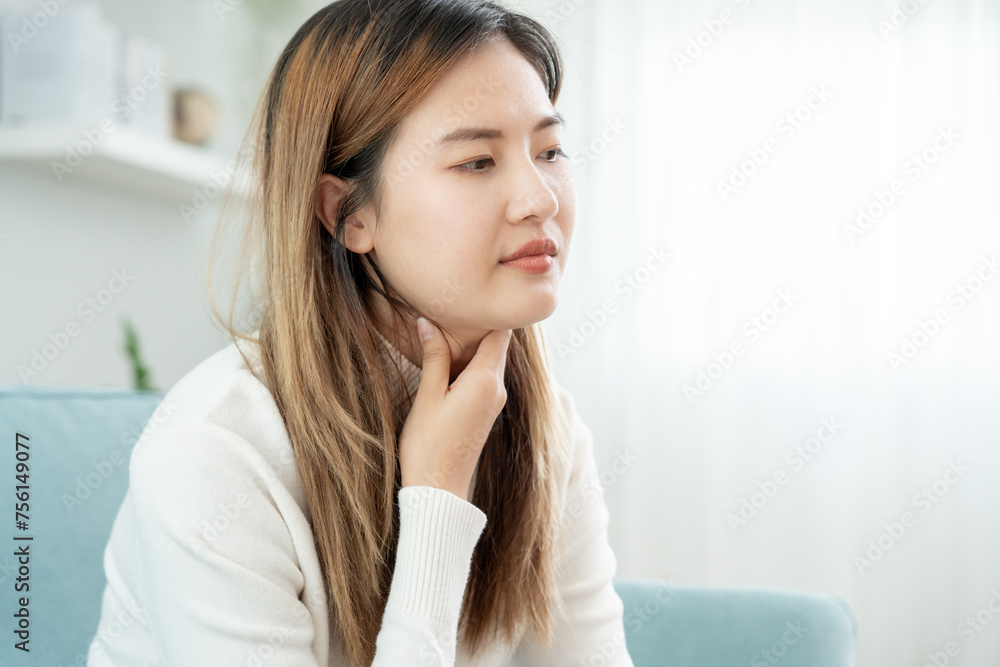 Asian woman put her hand on her neck due to a sore throat. female tonsillitis causes a ...