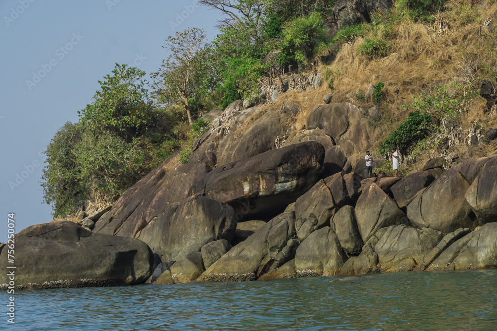 Two adults doing photography at a hill near butterfly beach in Goa ...