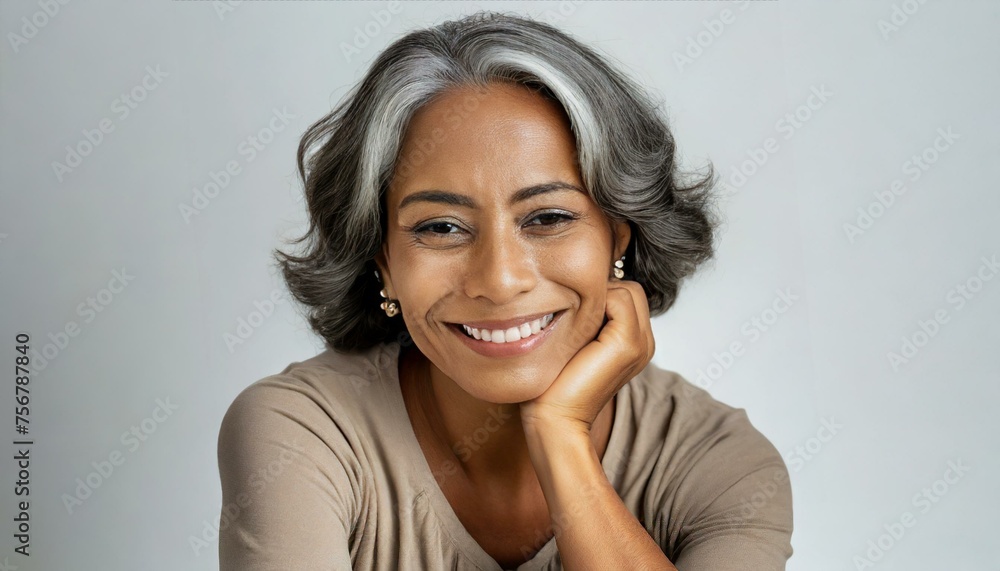 Beautiful mature Hispanic woman with greying hair looking at the camera ...