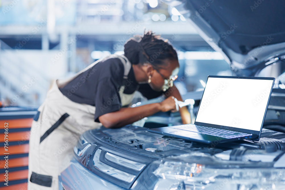 Mockup laptop next to mechanic changing old car transmission fluid with ...