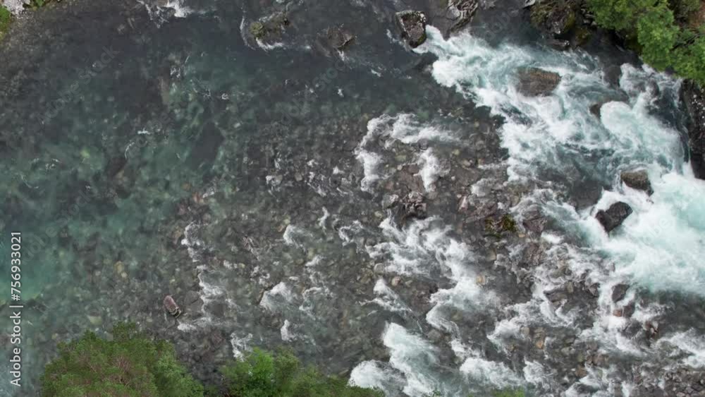 Bird's eye view of a corner in a wide, fast flowing river. White water ...
