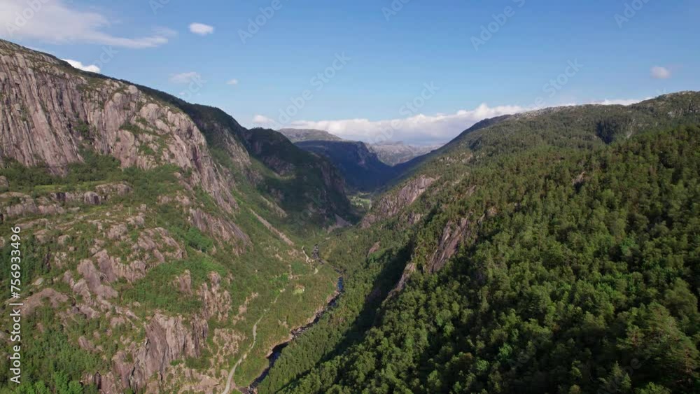 Aerial shot, descending into a deep valley with dense forest and steep ...