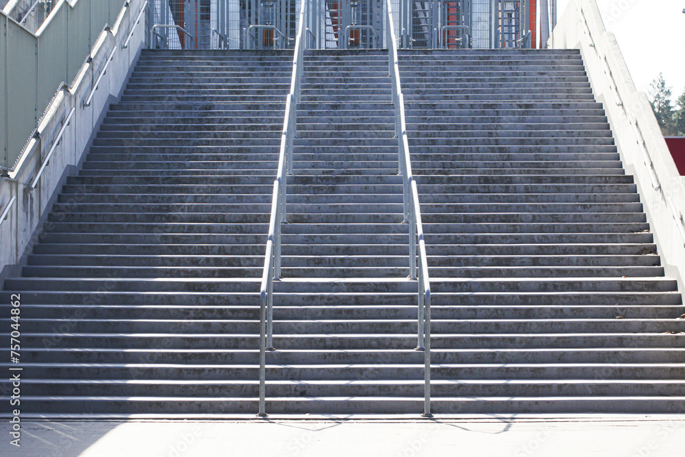 Long massive cementr stairs. Many steps background. Metal handrail ...