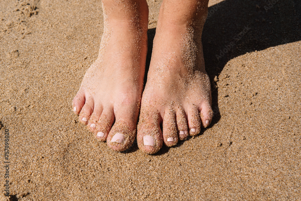 A person's feet are shown in the sand, with the toes sticking out Stock ...