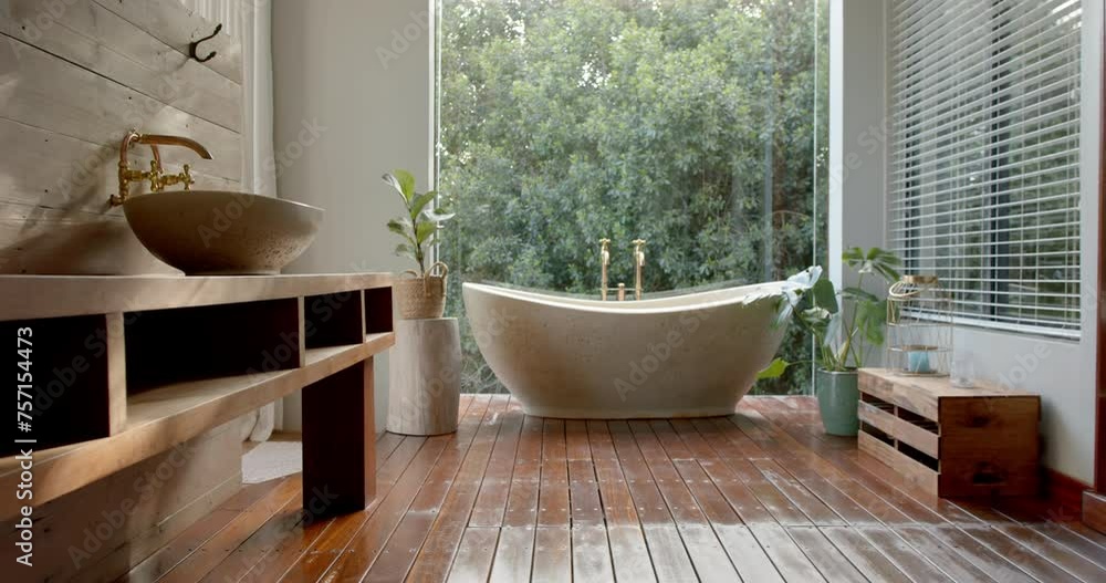 A modern bathroom features a freestanding bathtub and a wooden vanity ...