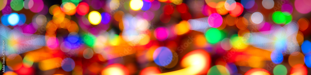 Numerous blurred colorful lights at a fun fair. Bright circles shine in ...