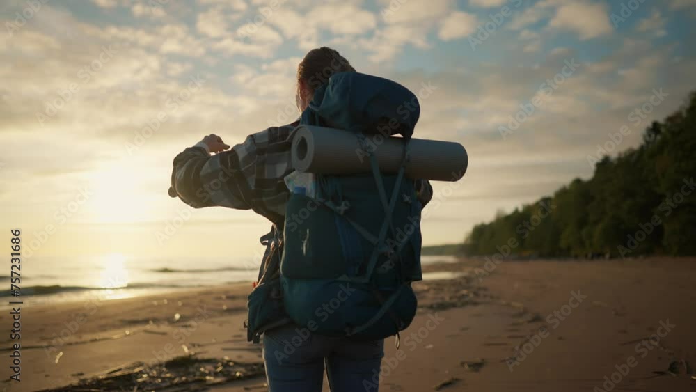 Woman tourist walks on sandy sea beach. Female traveler carrying big ...