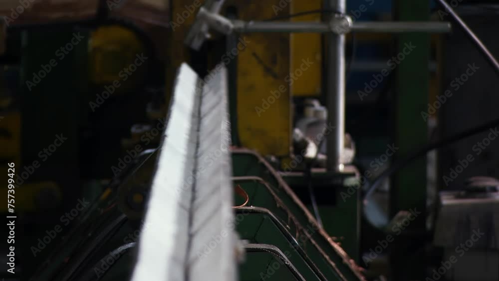 Production of a thin metal tube on an assembly line. The metal enters ...