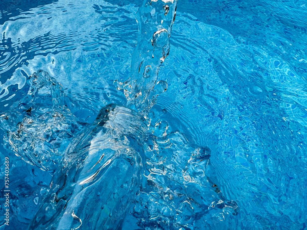 Dynamic splash in crystal clear blue water and glass bottle, creating ...