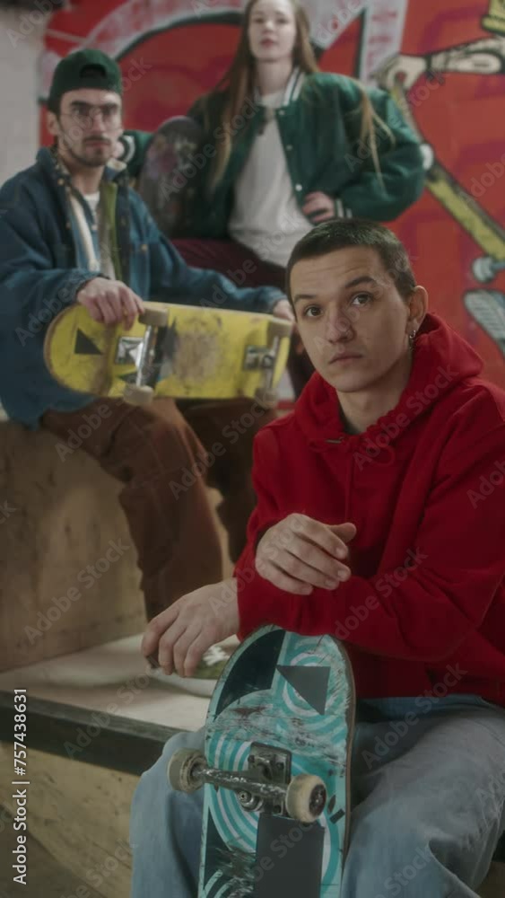 Vertical portrait of gen Z skateboarder looking at side and then ...