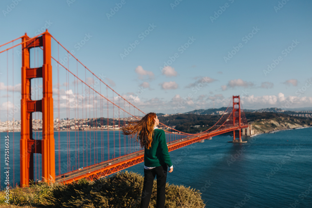 Back view woman stands in awe as the wind catches her hair, overlooking ...