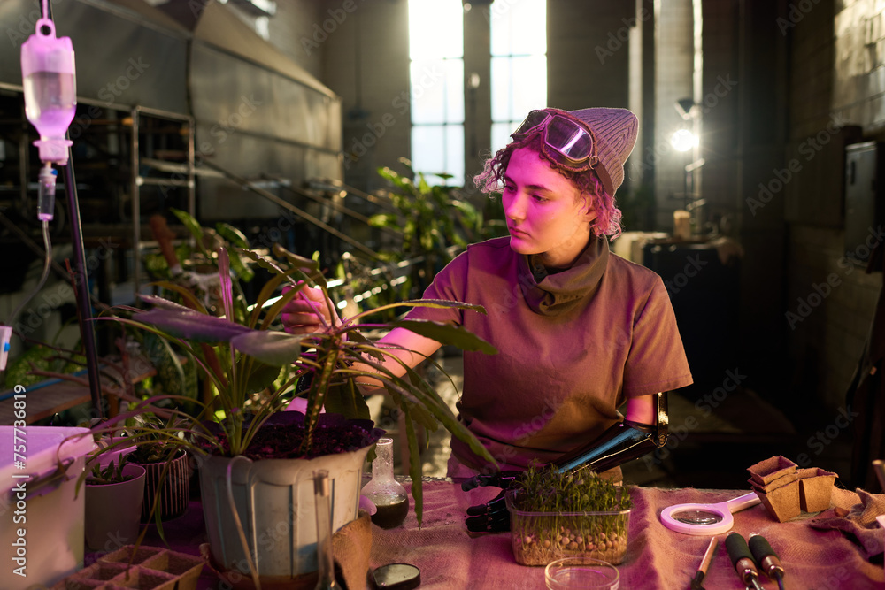 Caucasian woman with prosthetic arm wearing goggles on head working in ...