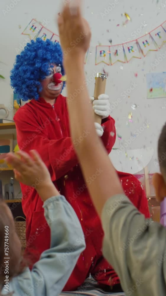 Back vertical slowmo of unidentified happy kids watching clown ...