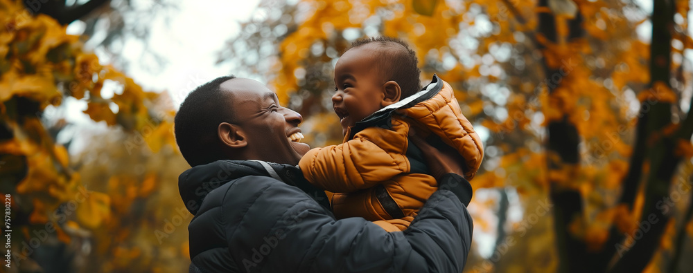 dark-skinned dad holds his little son in his arms and both laugh ...