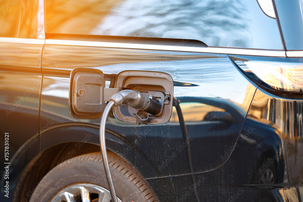Electric car recharge battery at parking lot. Charging plug closeup ...