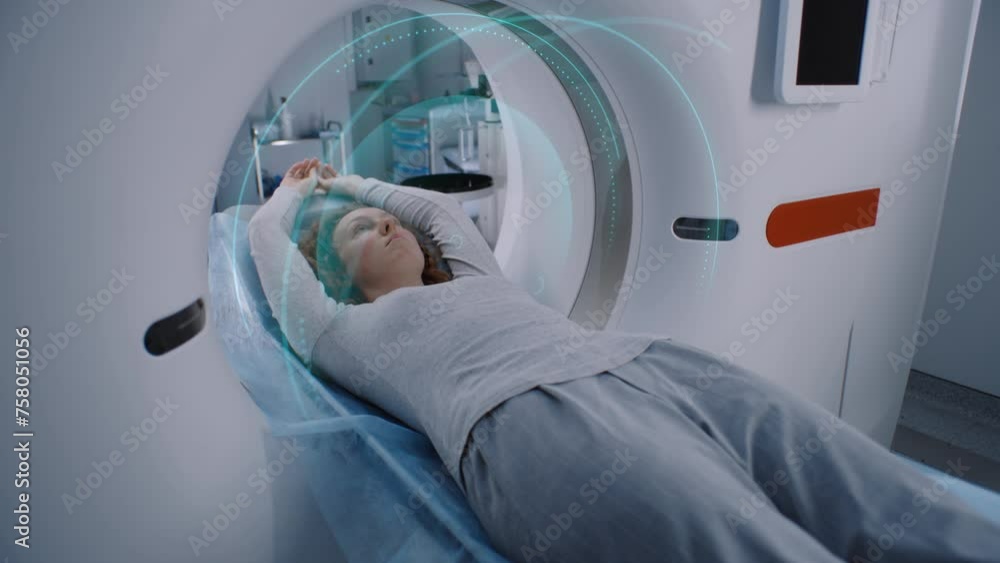 Female patient undergoes MRI or CT scan, lies on bed moving inside the ...