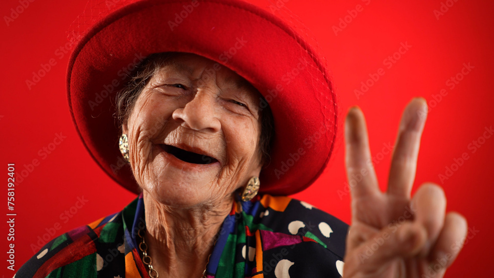 Playful, elderly mature woman, 80s, giving peace sign gesture with no ...
