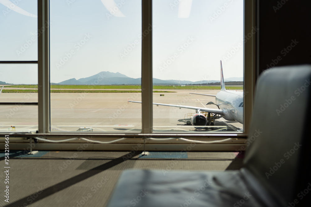 View from inside an airport with large window of the boarding gate overlooking the runways ...