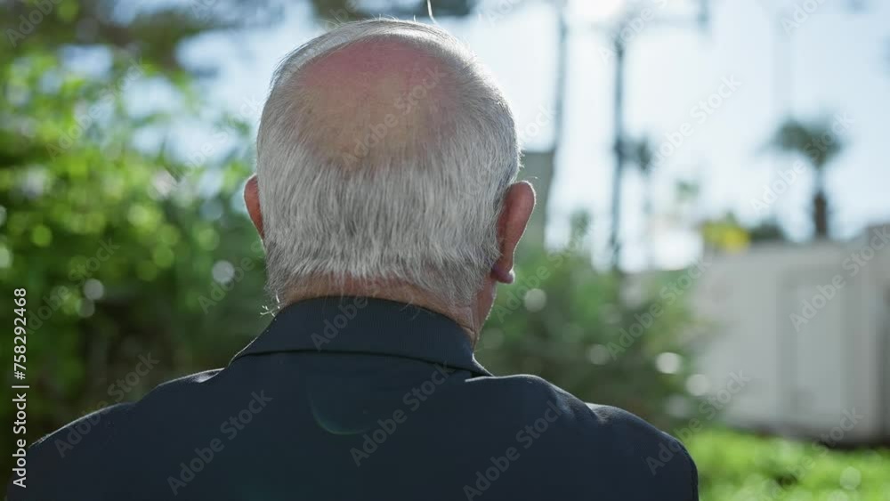 Casual portrait of a mature white-haired senior man standing backwards ...