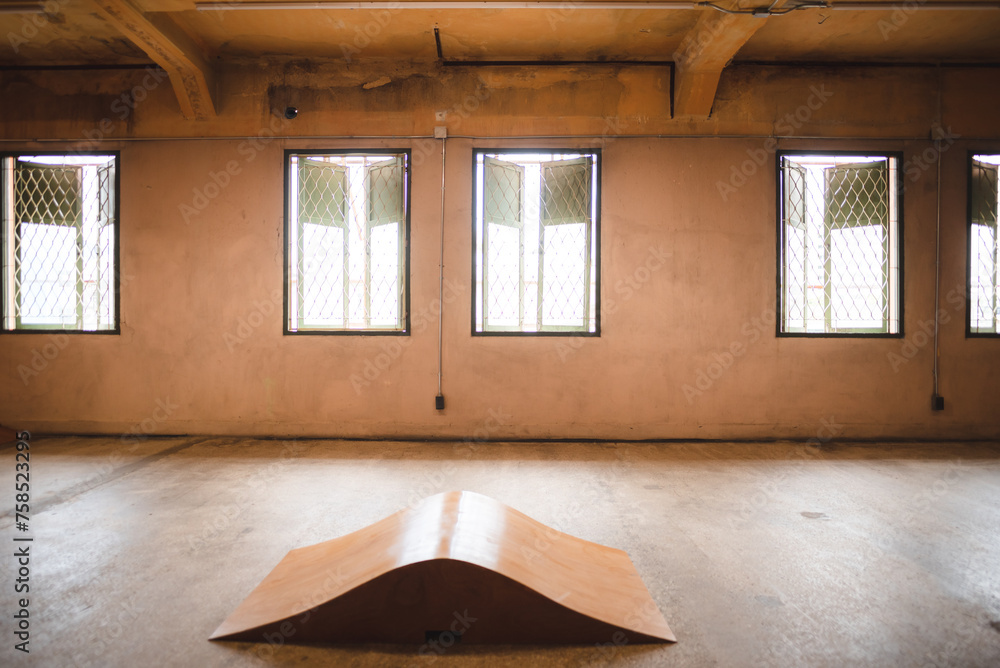Skateboard on the mini ramp at skate park indoor with brown wooden ...