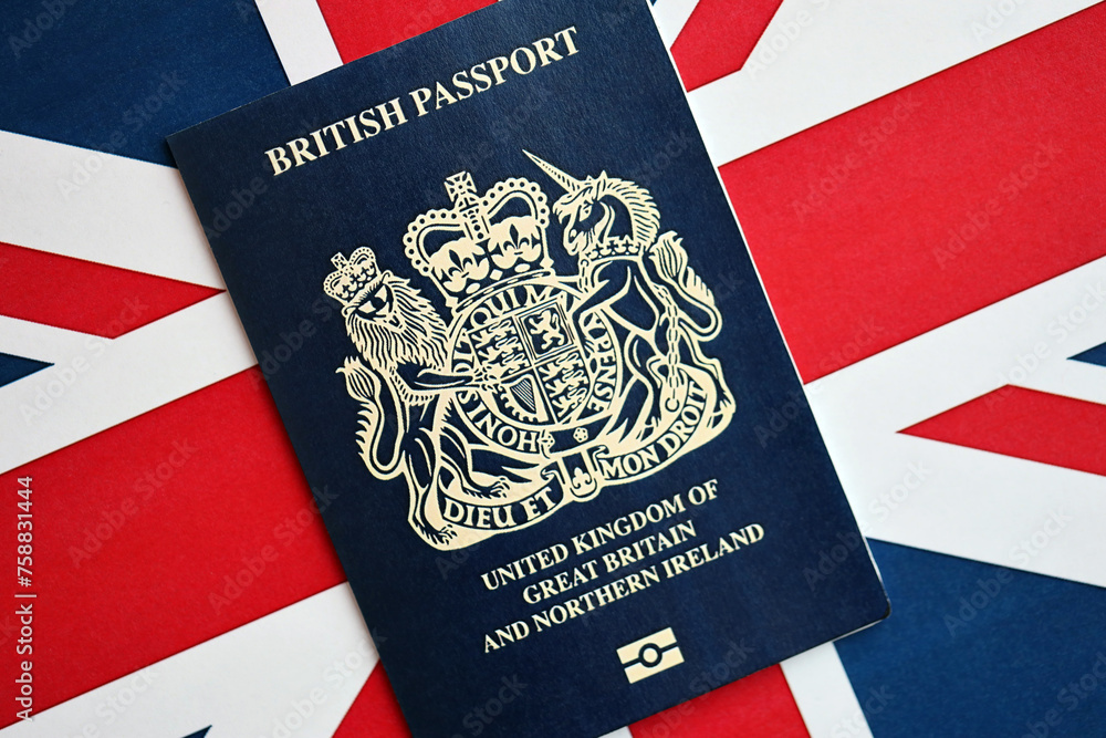 Blue British passport on national flag background close up. Tourism and ...