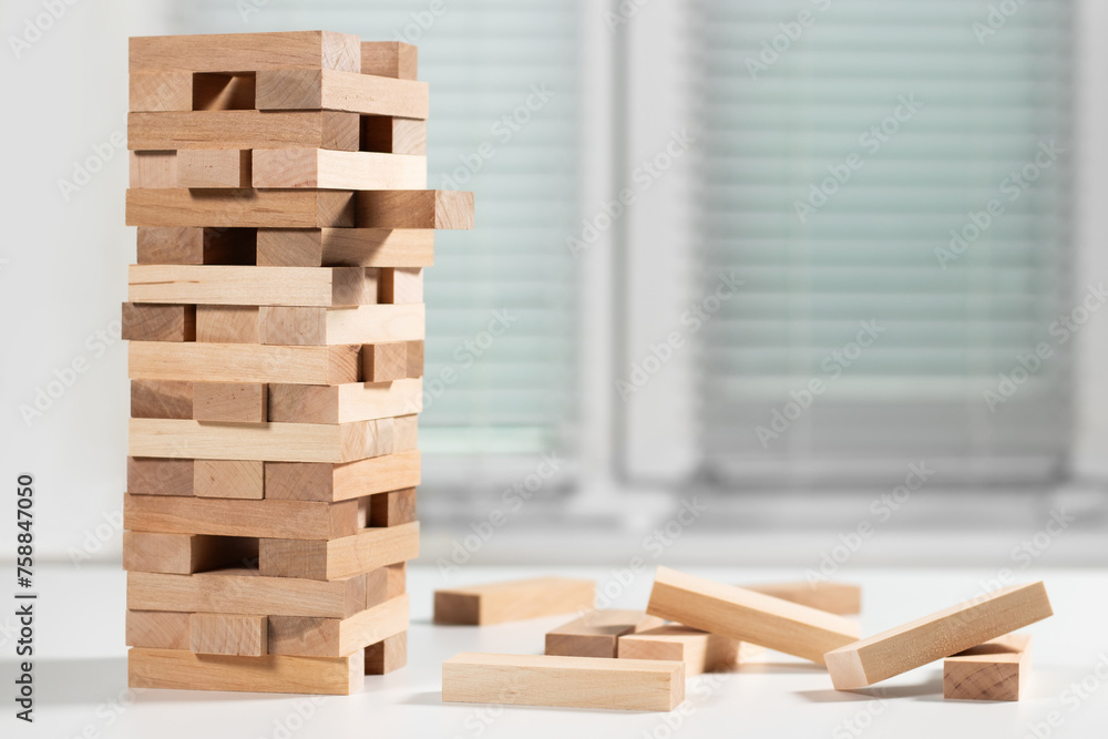 Board game Tower made of wooden blocks. A tower of unevenly shifted ...