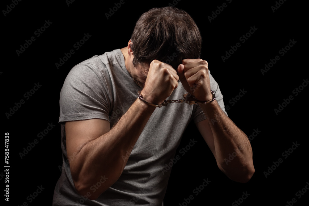 Handcuffed man covering his face with his hands. Arrested and ...