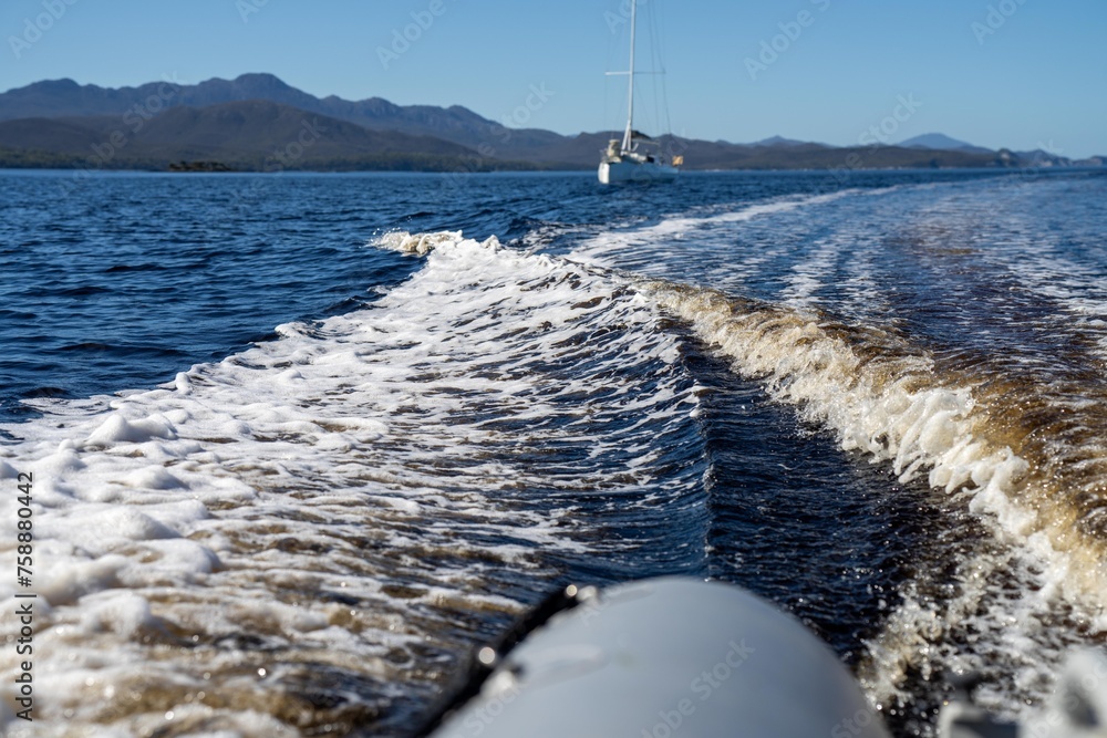 tinny dinghy boat on the water making a wake behind a boat making waves ...