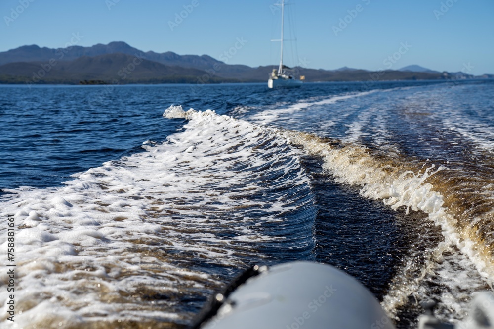 tinny dinghy boat on the water making a wake behind a boat making waves ...