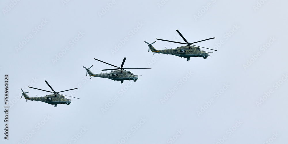 Three Russian military helicopters armed with missiles flies in blue ...